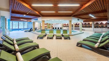 Uma área de spa com piscina, espreguiçadeiras e uma parede de pedra.