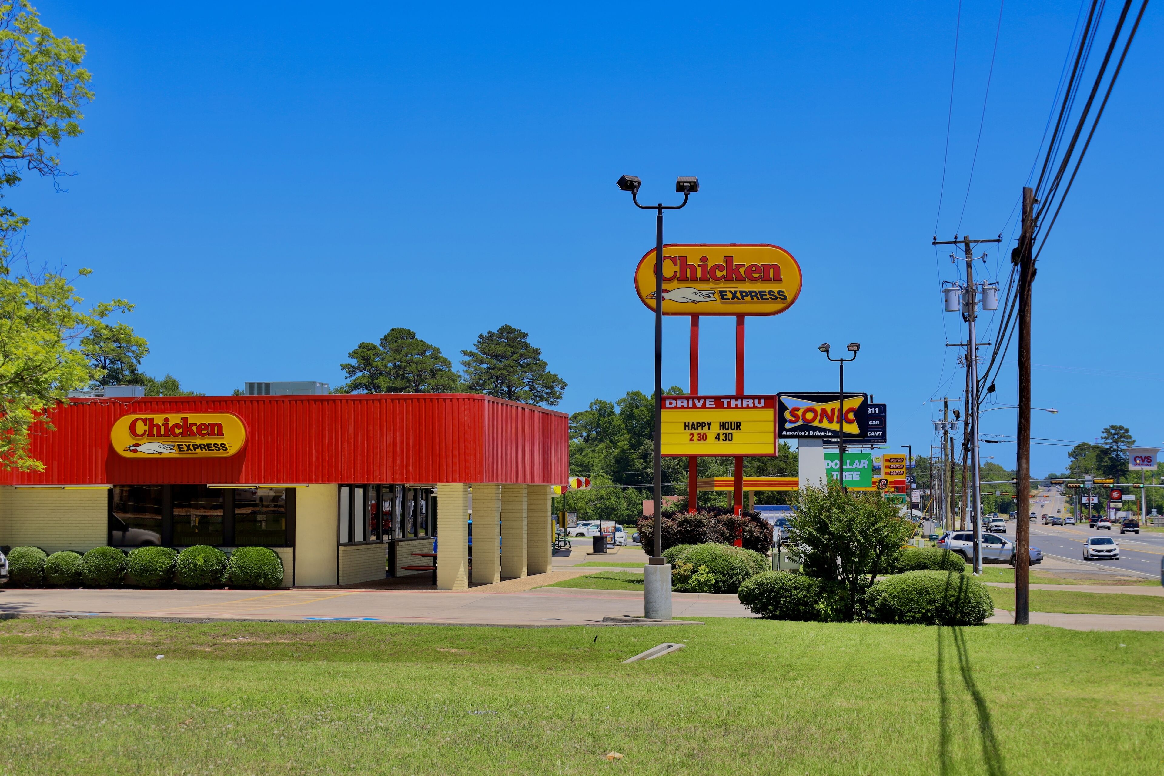 Restaurante Chicken Express com fachada vermelha e letreiro de drive-thru.