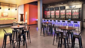 Uma área de bar com vários arranjos de assento e um balcão de bar bem abastecido.