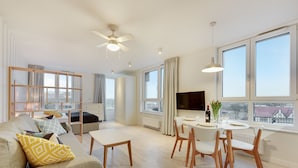Uma sala de estar moderna com sofá, mesa de centro e espaço de jantar.