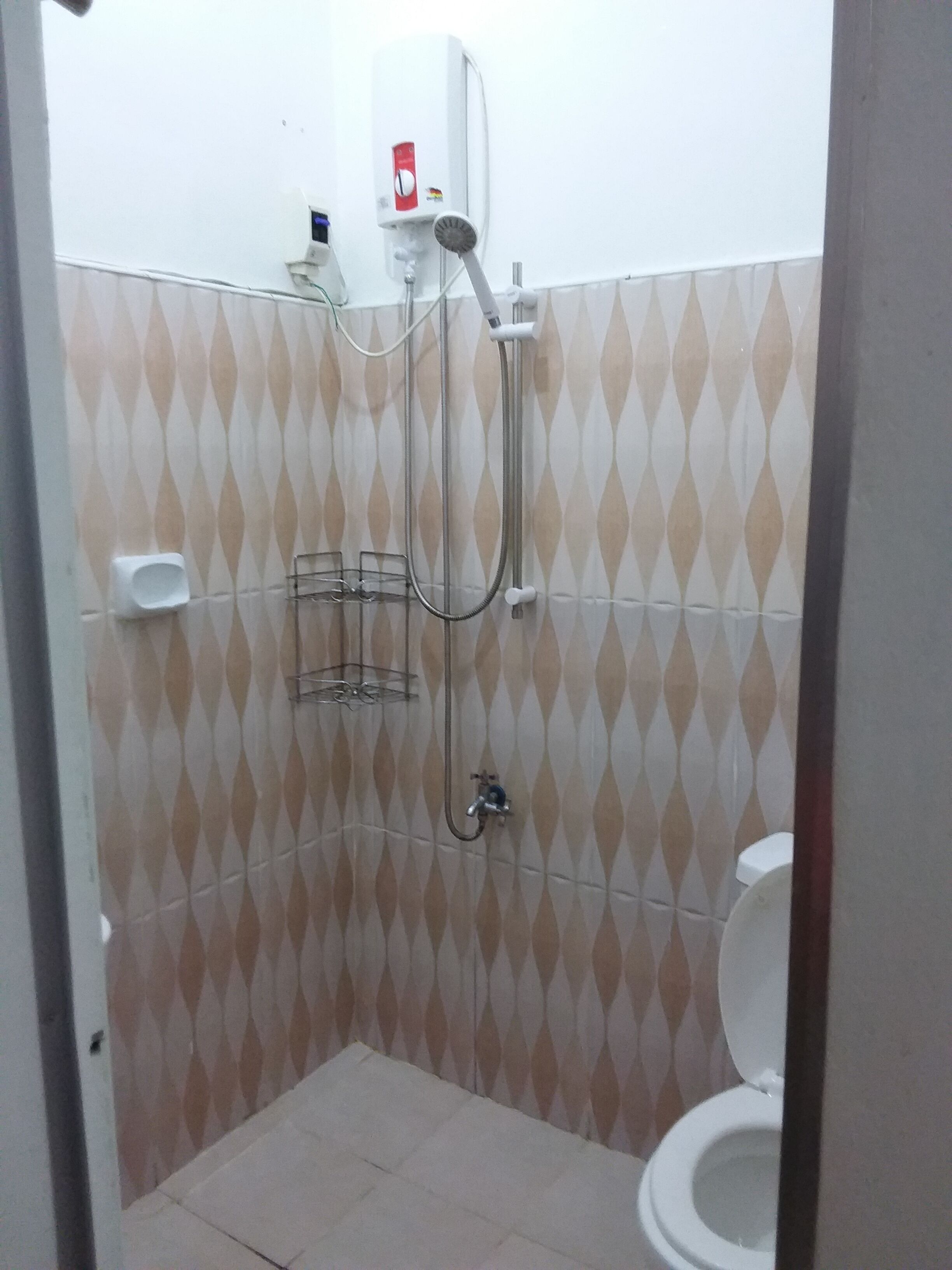Uma casa de banho pequena com chuveiro, sanita e secador de mãos.