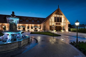 Hotel com uma grande fonte, área de estar externa e entrada bem iluminada.