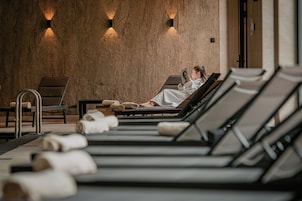 Uma área de spa com cadeiras reclináveis, toalhas e iluminação embutida.