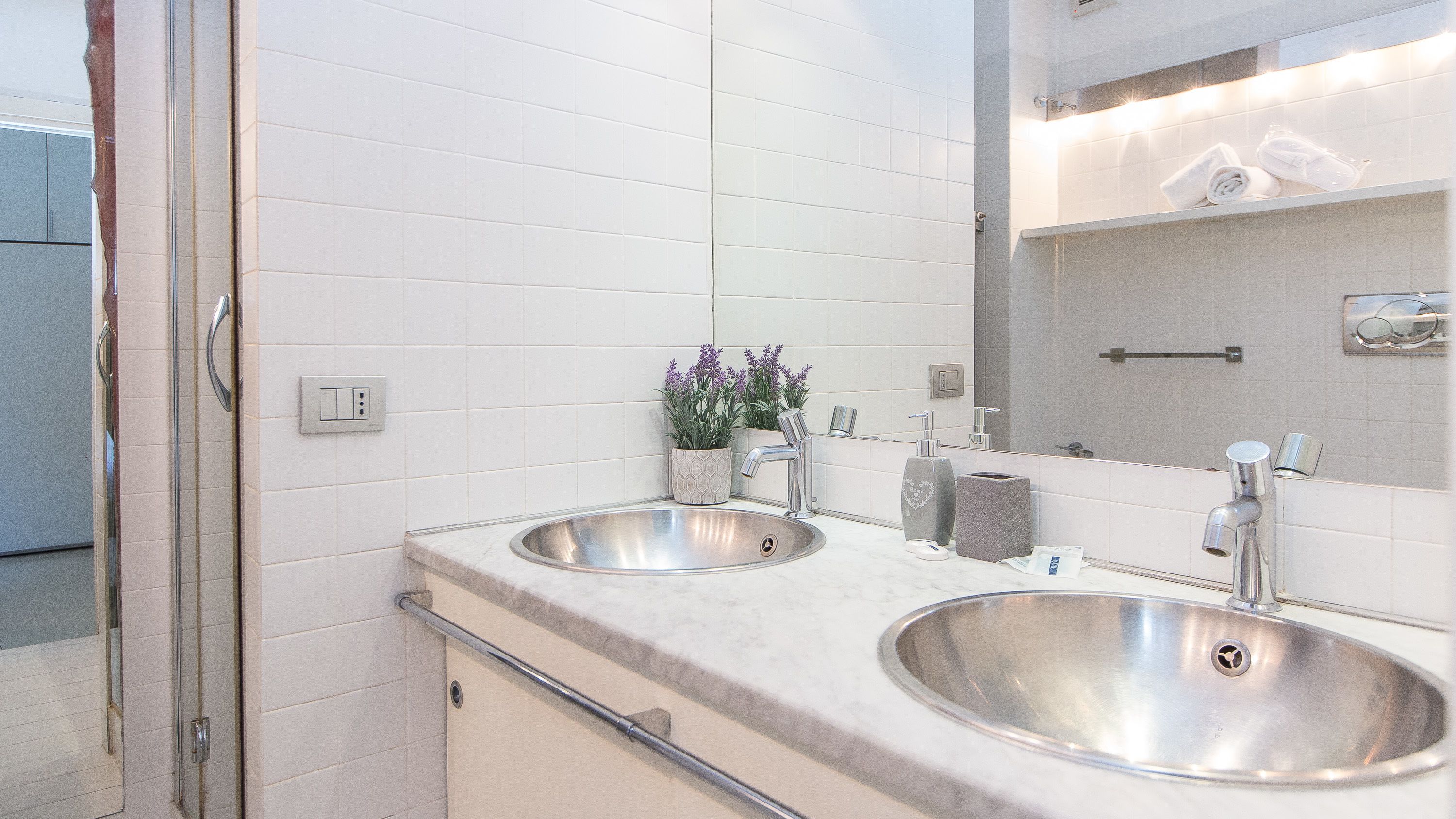 Casa de banho moderna com duas pias, um espelho e um porta-toalhas.