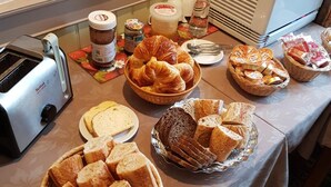 Um buffet de café da manhã com pães, croissants e doces sobre uma mesa.