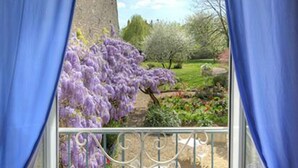 Varanda com vista para flores roxas e um jardim.