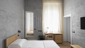 Quarto moderno com cama, escrivaninha e cadeira, uma porta e uma janela com cortinas.