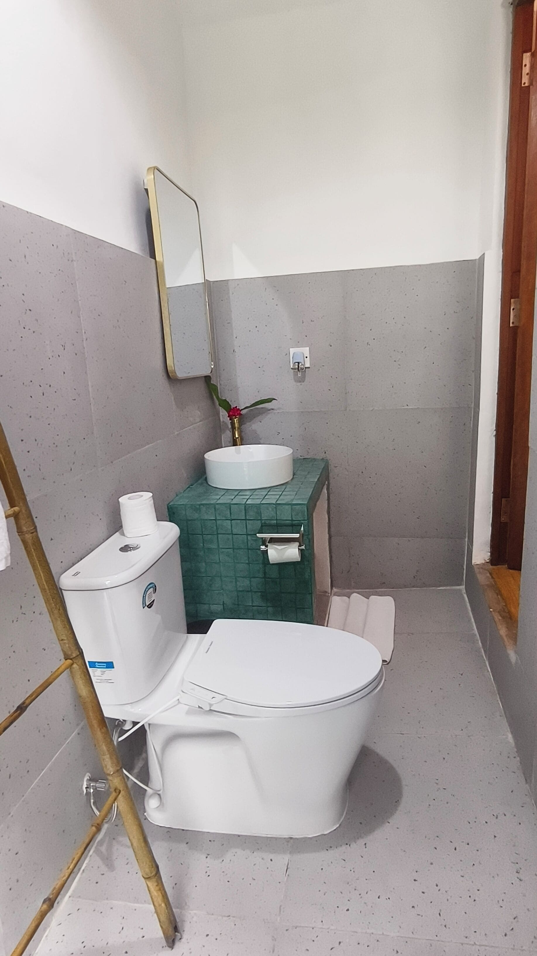 Um banheiro pequeno com vaso sanitário, pia e espelho.