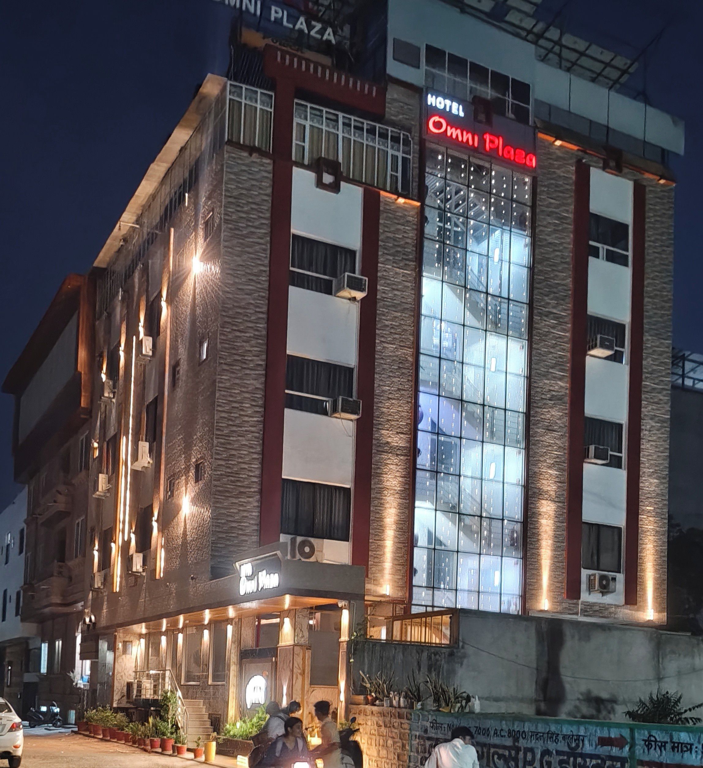 Um hotel com vários andares e uma placa de destaque com os dizeres 'Omni Plaza' e 'Hotel Omni Plaza'.
