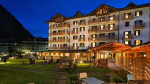 Um hotel com vários andares, área de estar externa e um terraço coberto.