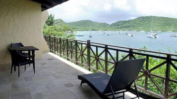 Varanda com mesa e cadeiras com vista para uma marina e barcos.