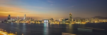 Paisagem urbana noturna com edifícios iluminados ao longo da orla.