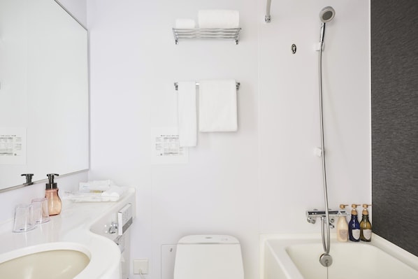 Um banheiro moderno com pia branca, vaso sanitário, chuveiro com chuveiro manual e porta-toalhas.