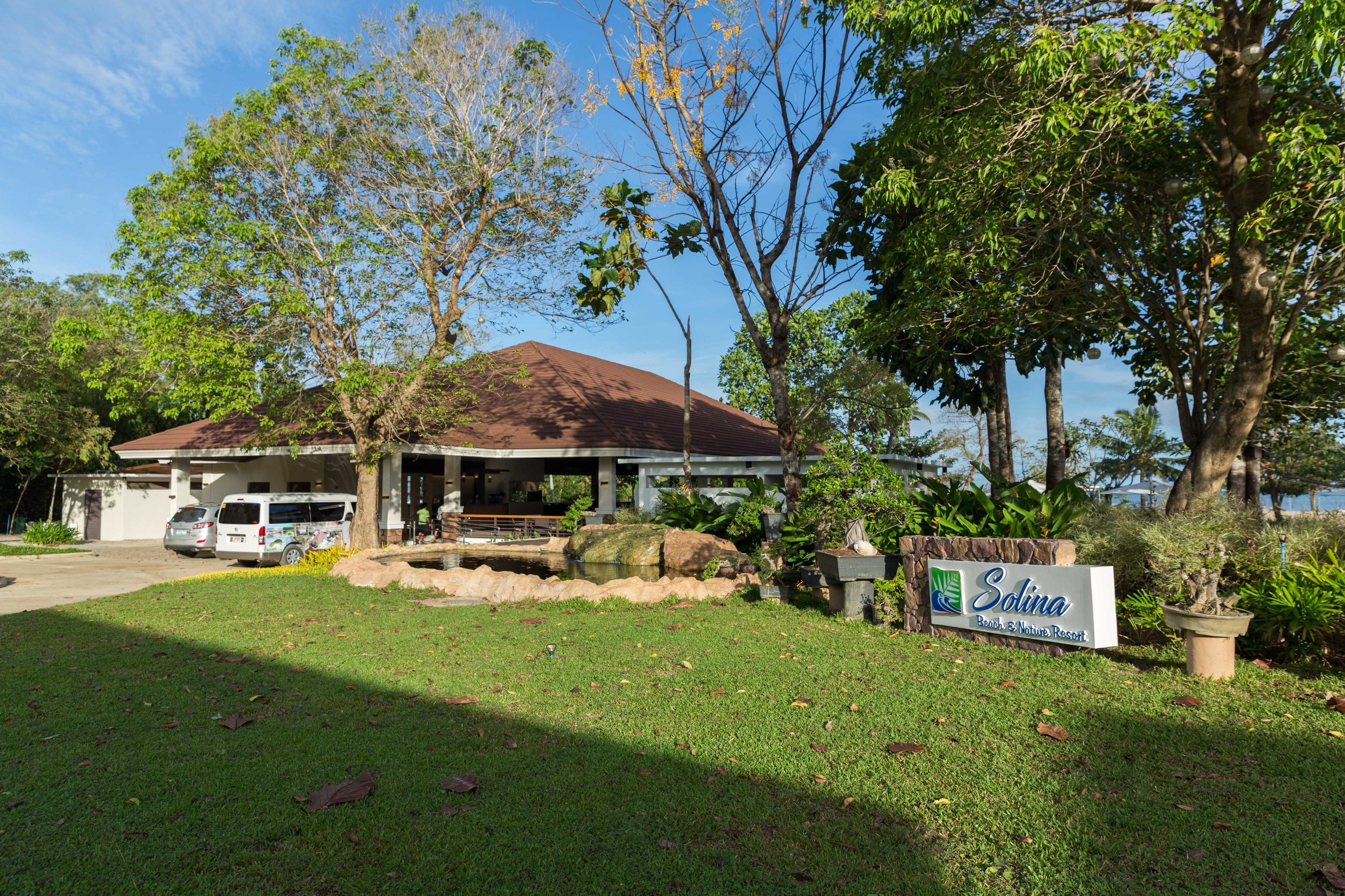 Resort com área externa coberta, piscina e placa indicando 'Solina Beach & Nature Resort'.