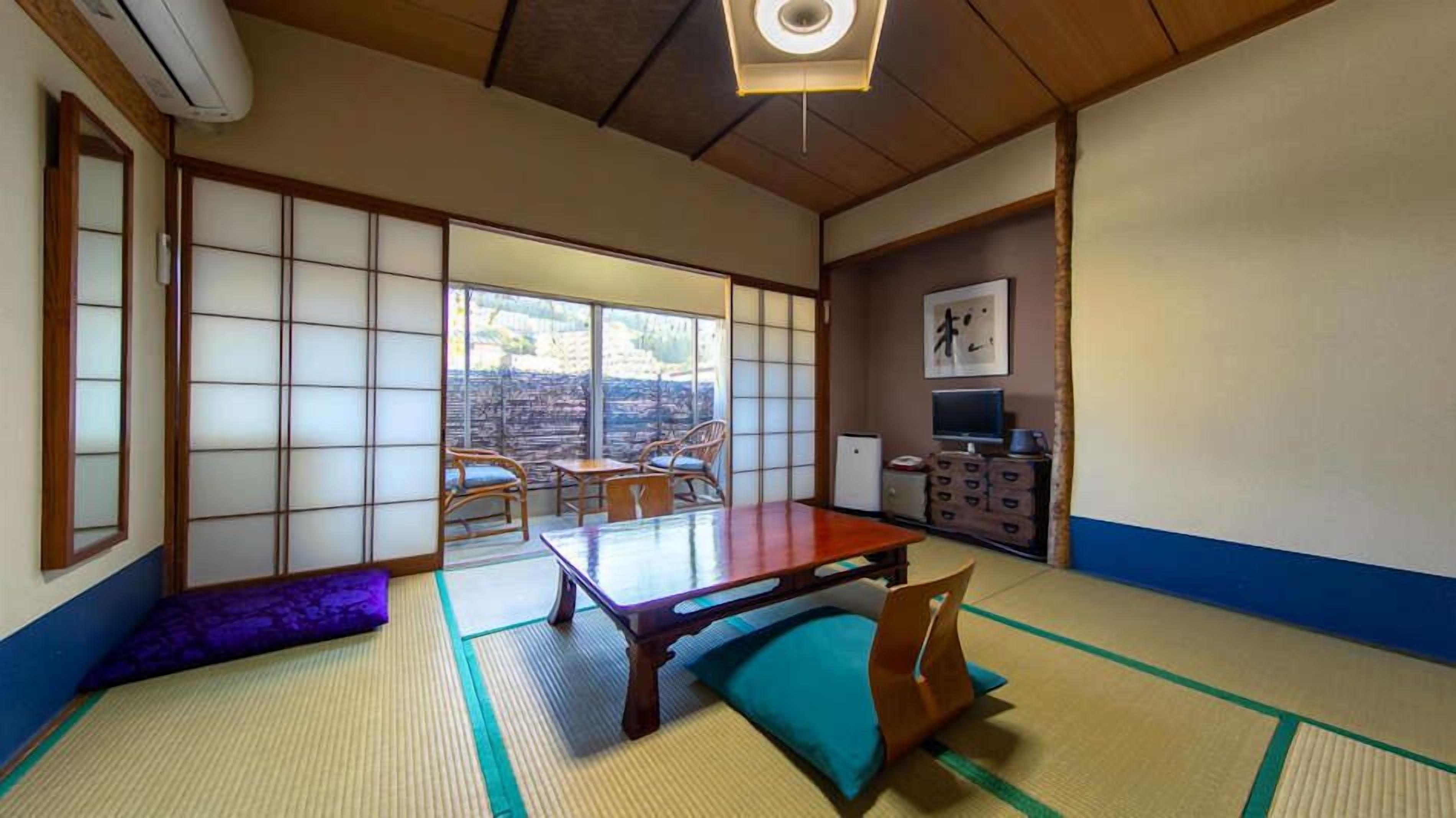 Um quarto japonês tradicional, com piso de tatame, uma mesa baixa e portas deslizantes.