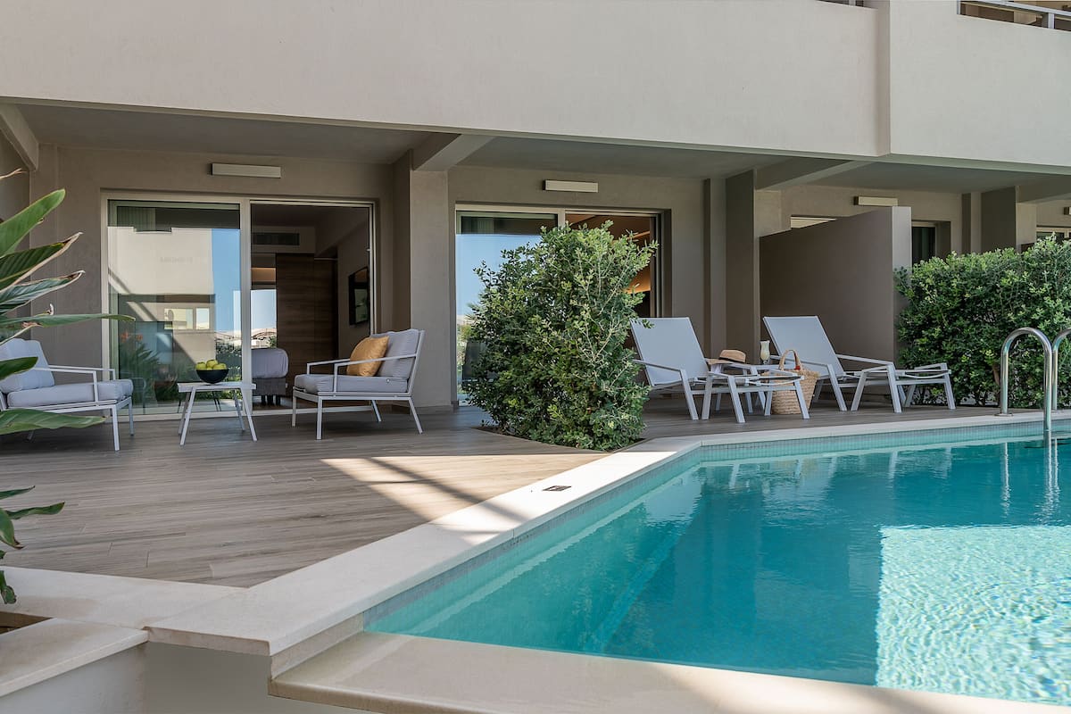 Uma área moderna com piscina ao ar livre, espreguiçadeiras e deck de madeira.