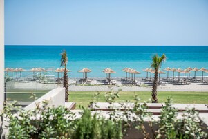 Na praia, espreguiçadeiras, guarda-sóis de praia, toalhas de praia 