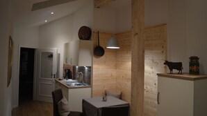 Cozinha compacta com pia, fogão e luminária pendente.