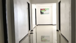 Um corredor comprido e estreito, com paredes brancas e piso brilhante.