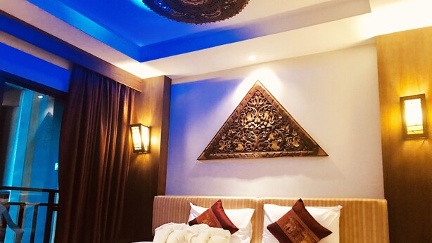 Quarto de hotel com cama, um objeto decorativo na parede e vista para o exterior.