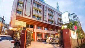 Um hotel com vários andares, com varandas e uma placa com a inscrição 'Hotel Plaza Inn'.