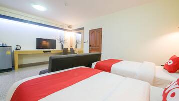 Quarto de hotel com duas camas, uma escrivaninha, televisão e uma porta.