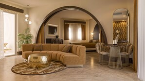 Uma sala de estar moderna com um sofá seccional, uma mesa de centro redonda e um espaço de jantar com mesa e cadeiras circulares.