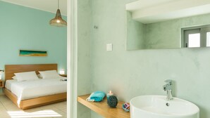 Quarto com cama, mesa de cabeceira e criado-mudo.