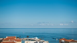 Uma vila costeira com edifícios e um cais que se estende para o mar.