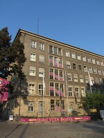 Um edifício de vários andares com a placa Hotel Vita Berlin.