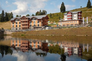 Um hotel com vários edifícios de madeira e reflexo na água.