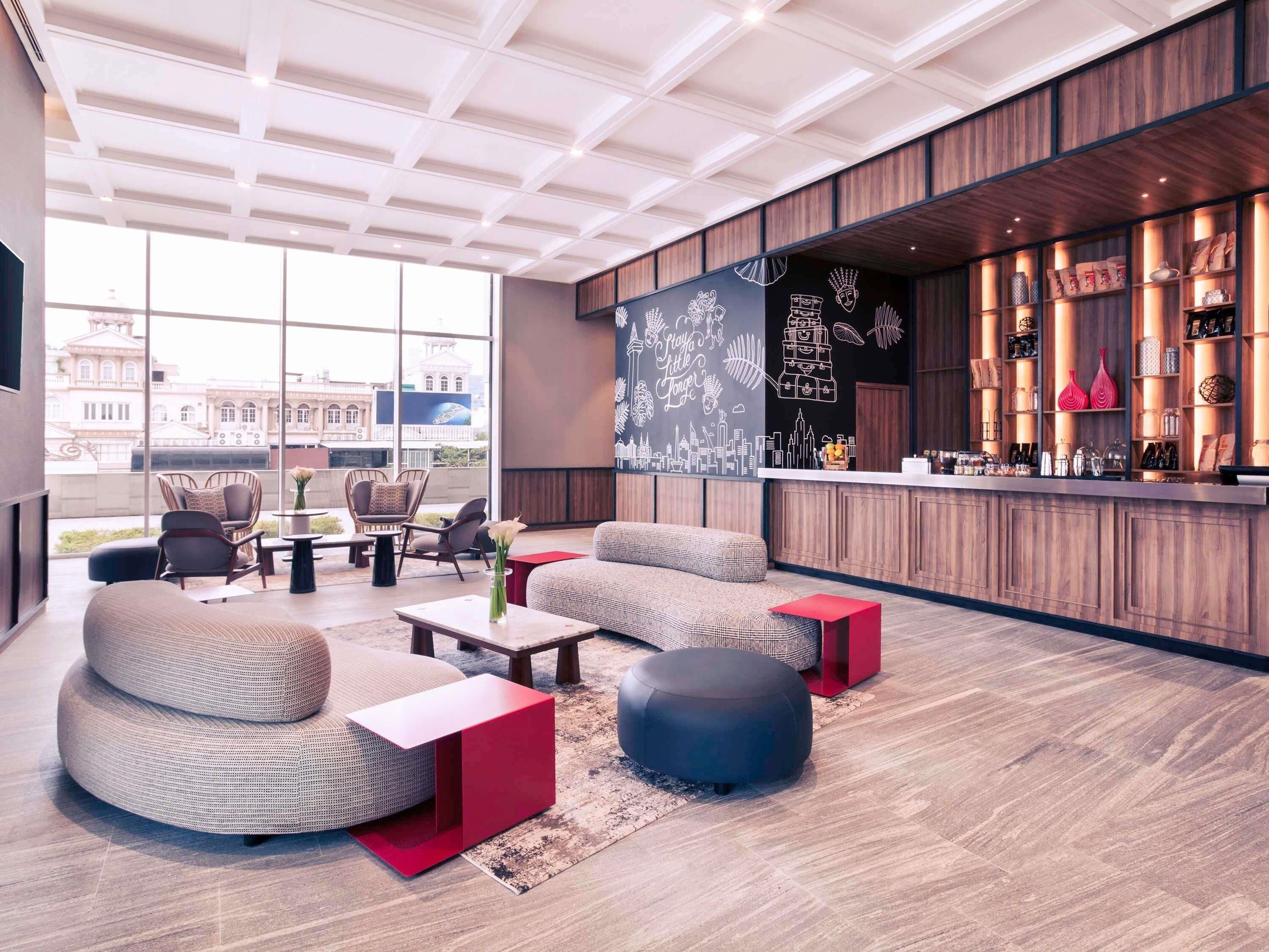 Uma área de estar moderna com assentos, bar e vista para a cidade.
