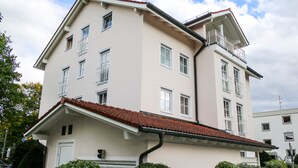Um edifício com vários andares, teto plano e paredes externas brancas.