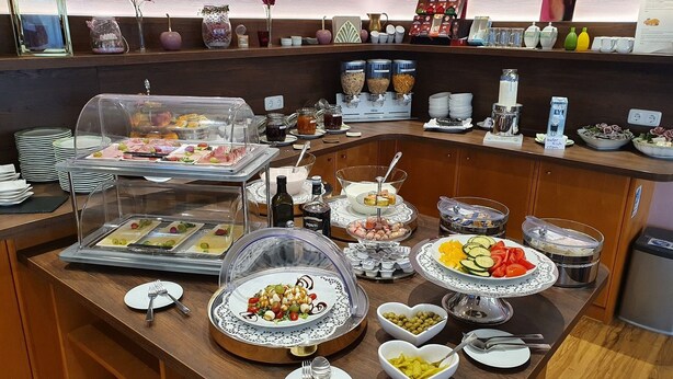 Uma mesa de buffet com diversos alimentos e acompanhamentos.