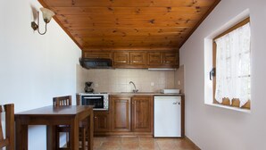 Uma cozinha com armários de madeira, uma geladeira branca e uma mesa de jantar com cadeiras.