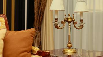 Um quarto luxuoso com uma mesa de candelabro dourado, um sofá macio e cortinas elegantes.