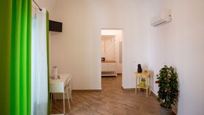 Um quarto com uma mesa, cadeira e um vaso de planta.
