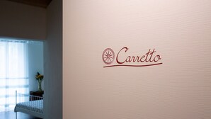 Corredor com parede branca exibindo o logotipo "Carretto" e um símbolo decorativo de roda.