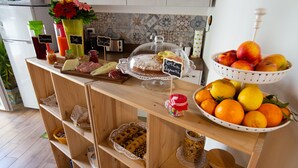 Buffet com diversos alimentos e uma cesta de frutas.