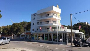 Um edifício com vários andares, incluindo um restaurante no térreo e apartamentos nos andares superiores.