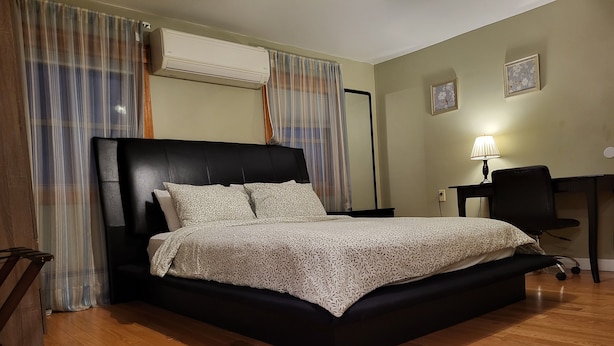 Um quarto com uma cama, uma escrivaninha e uma cadeira.