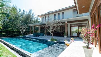 Uma casa moderna com piscina, área de estar externa e jardim.