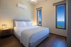 Quarto com cama, mesas de cabeceira, ar condicionado e janela com vista.