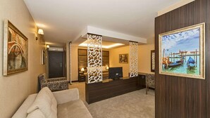Sala de estar com sofá, televisão e painéis decorativos.