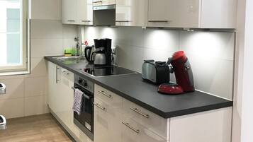 Um frigorífico, um micro-ondas, um forno, uma placa de cozinha