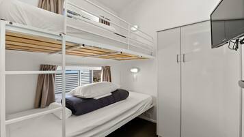 Quarto com beliche, guarda-roupa e televisão.