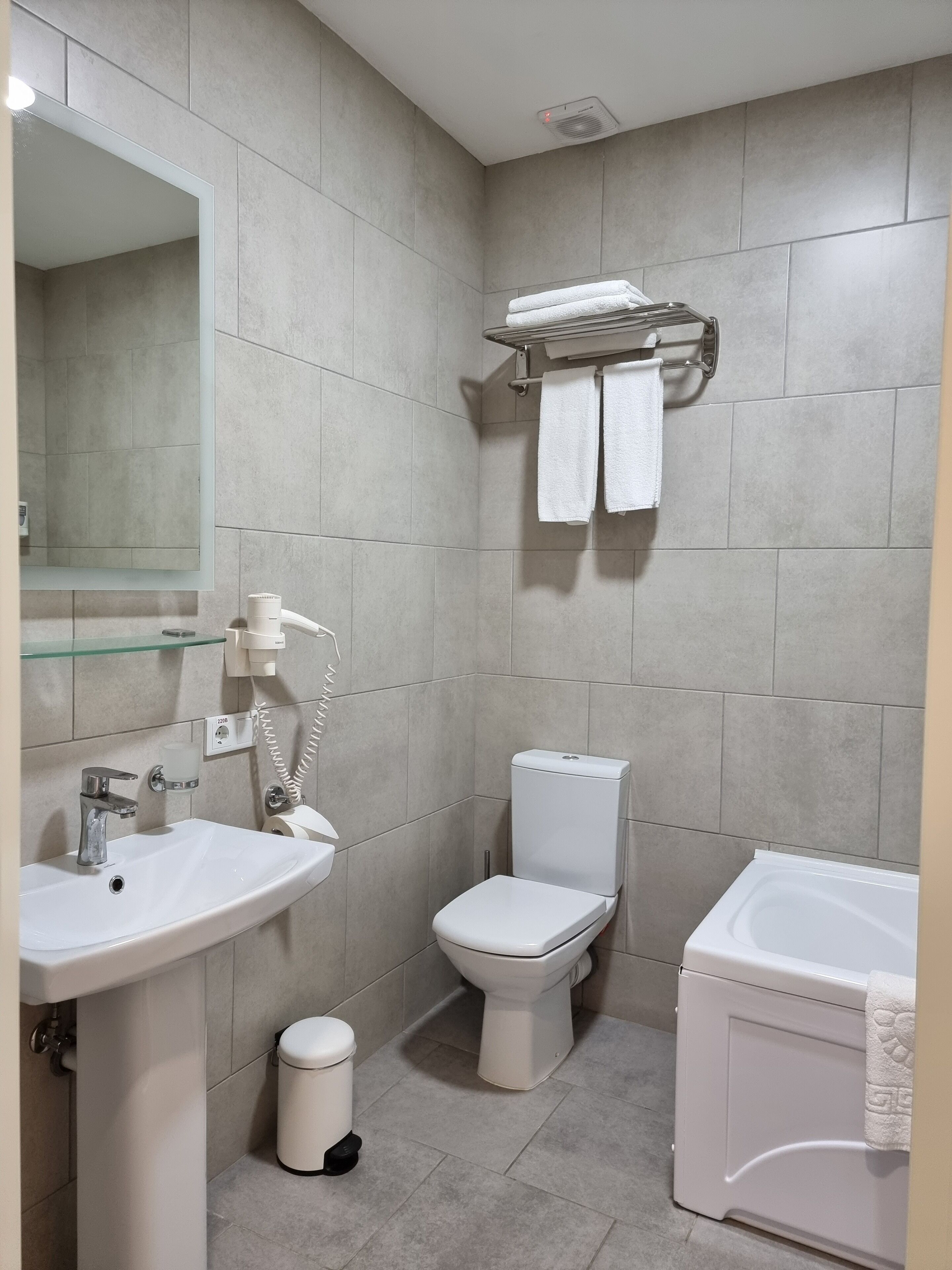 Casa de banho moderna com lavatório, sanita e banheira.