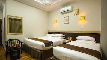 Quarto de hotel com duas camas, uma mesa com cadeira, ar condicionado e luminárias na parede.