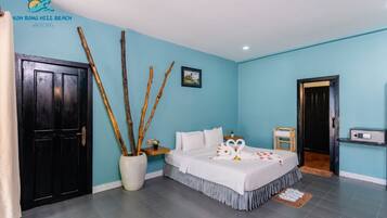 Quarto com cama, mesa de cabeceira, planta em vaso e um quadro na parede.