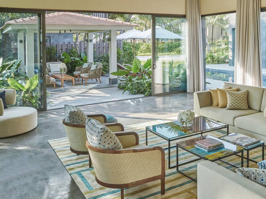 Uma sala de estar ampla com sofá, poltronas e mesa de centro.
